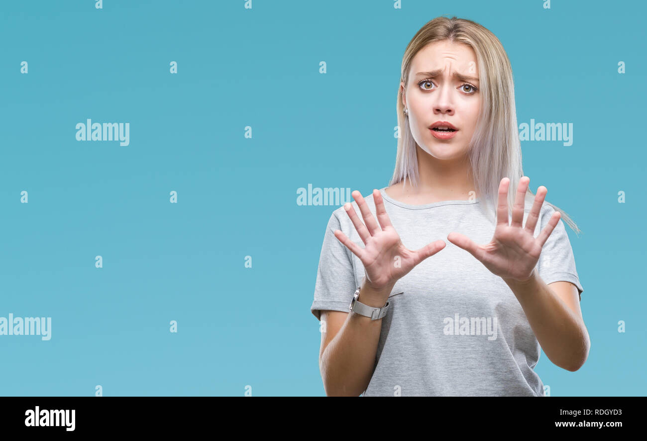 Young blonde woman over isolated background afraid and terrified with ...
