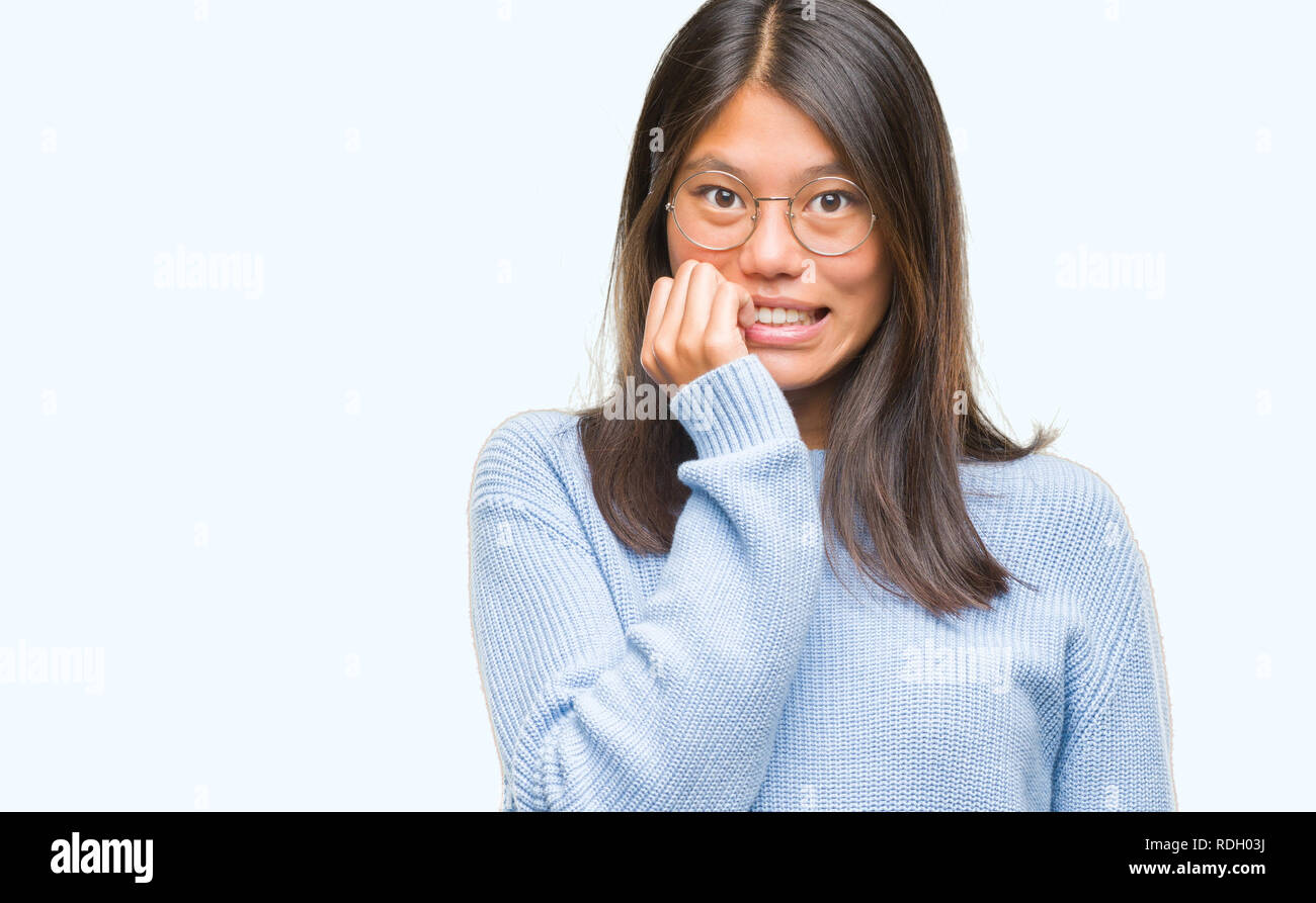 Young asian woman wearing winter sweater over isolated background ...