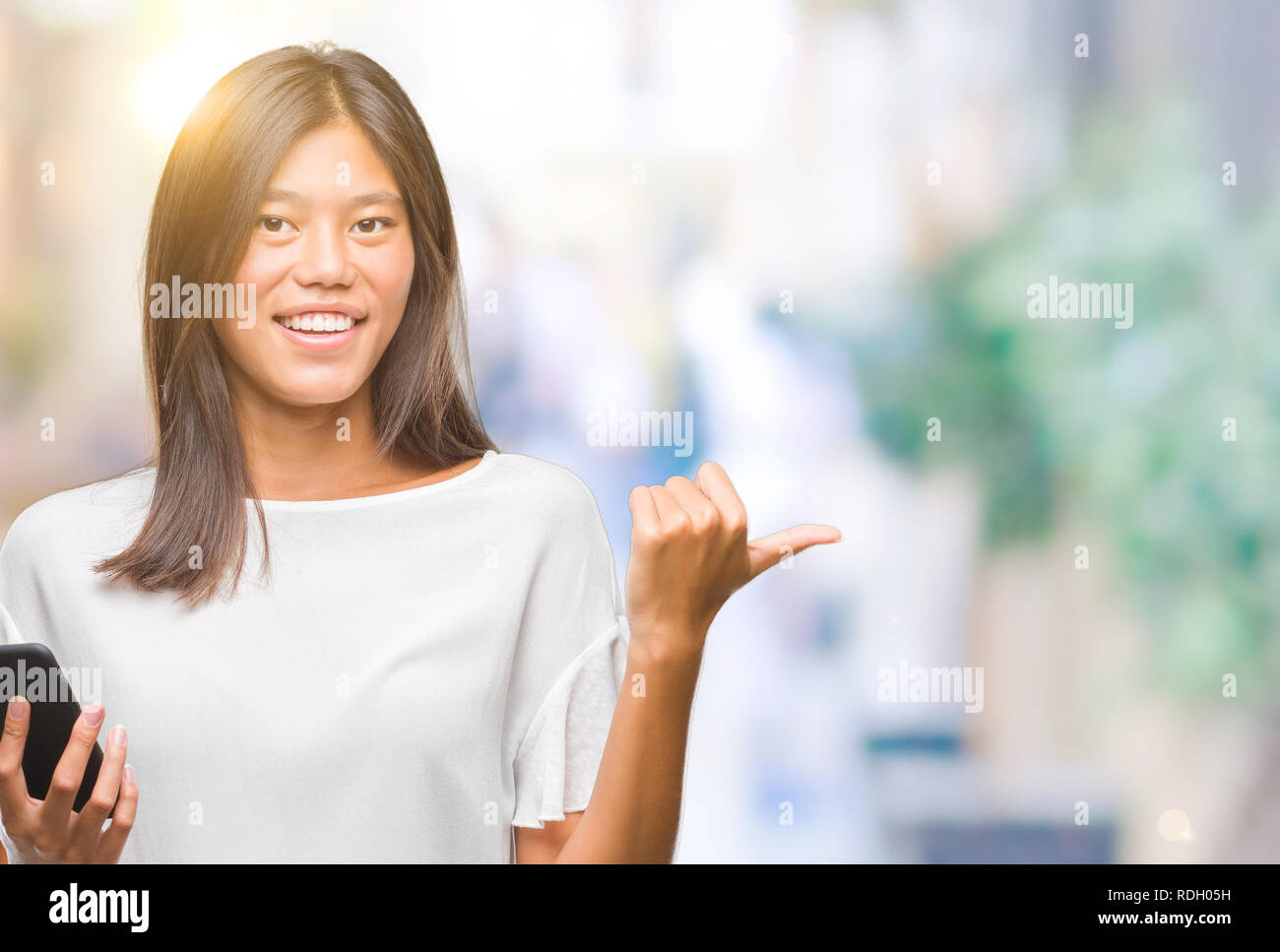 Young asian woman texting using smartphone over isolated background ...