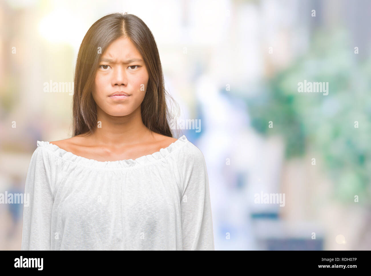Young asian woman over isolated background skeptic and nervous ...