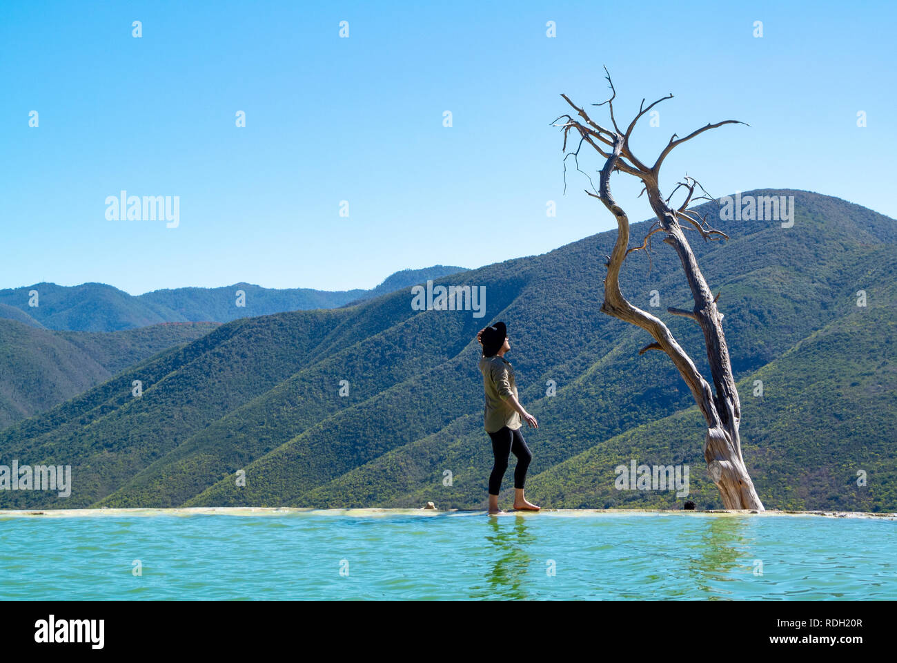 A tourist on the edge od a lake done by petrified waterfall, Hierve el ...