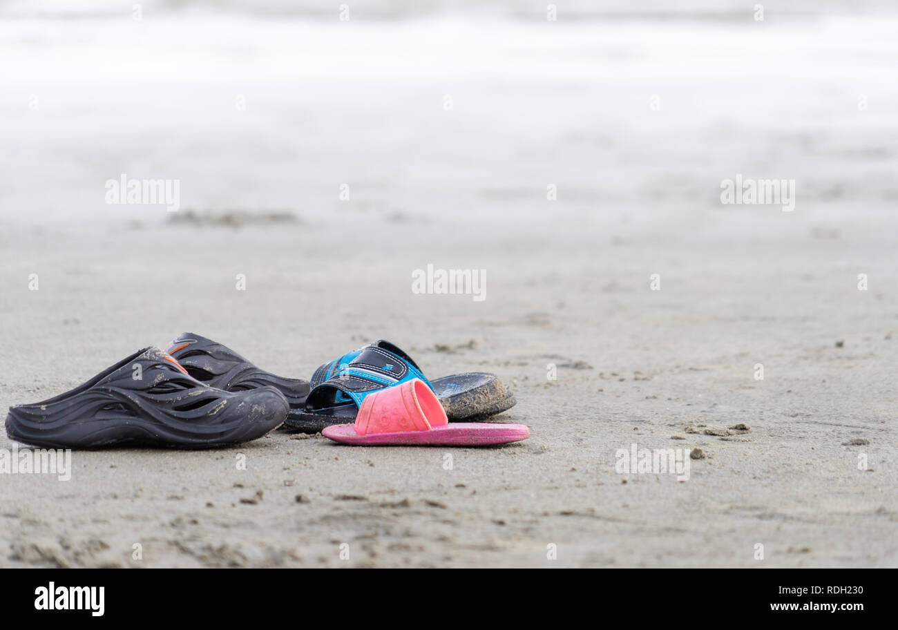 Family sandals left on the beach Stock Photo - Alamy