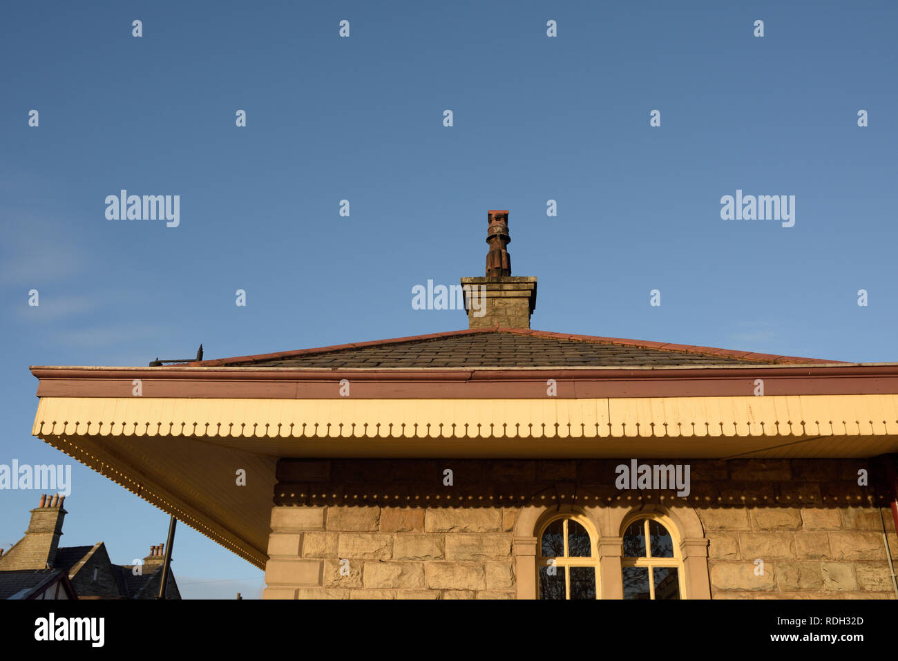 East lancashire railway station building with stone wall and sloping ...