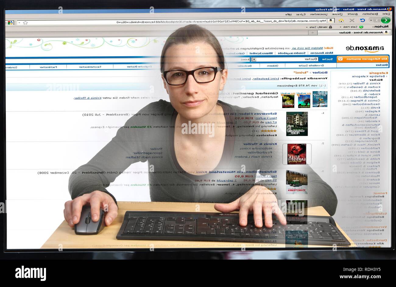 Young woman sitting at a computer surfing the Internet, viewing a page ...