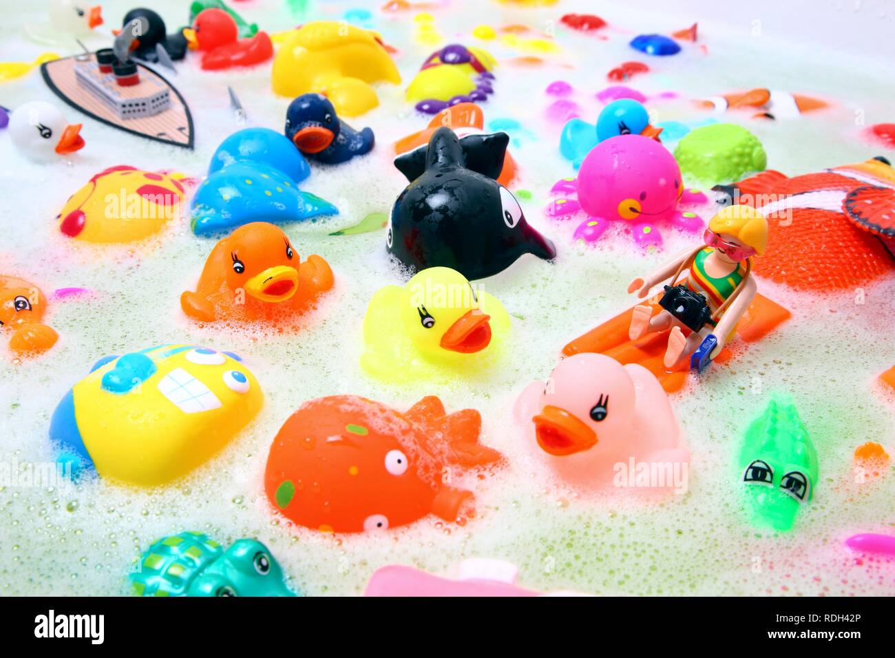 Various colourful water toys with bath foam Stock Photo - Alamy