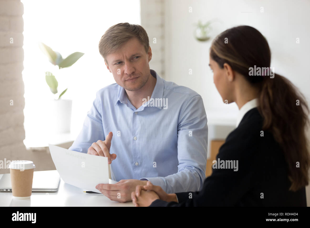 Doubting hr manager looking with suspicion at applicant Stock Photo - Alamy