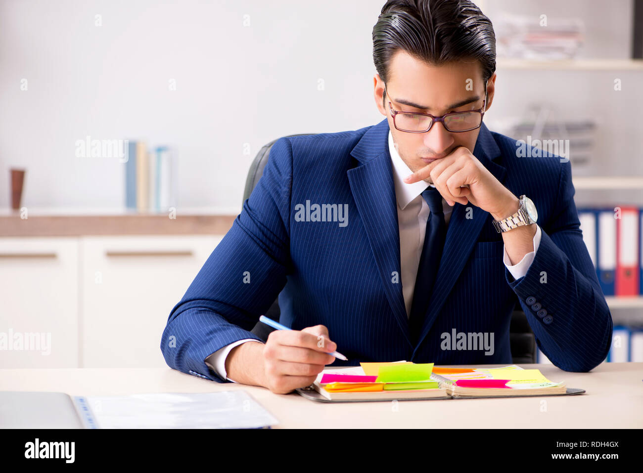 Young handsome employee planning his work activity Stock Photo - Alamy