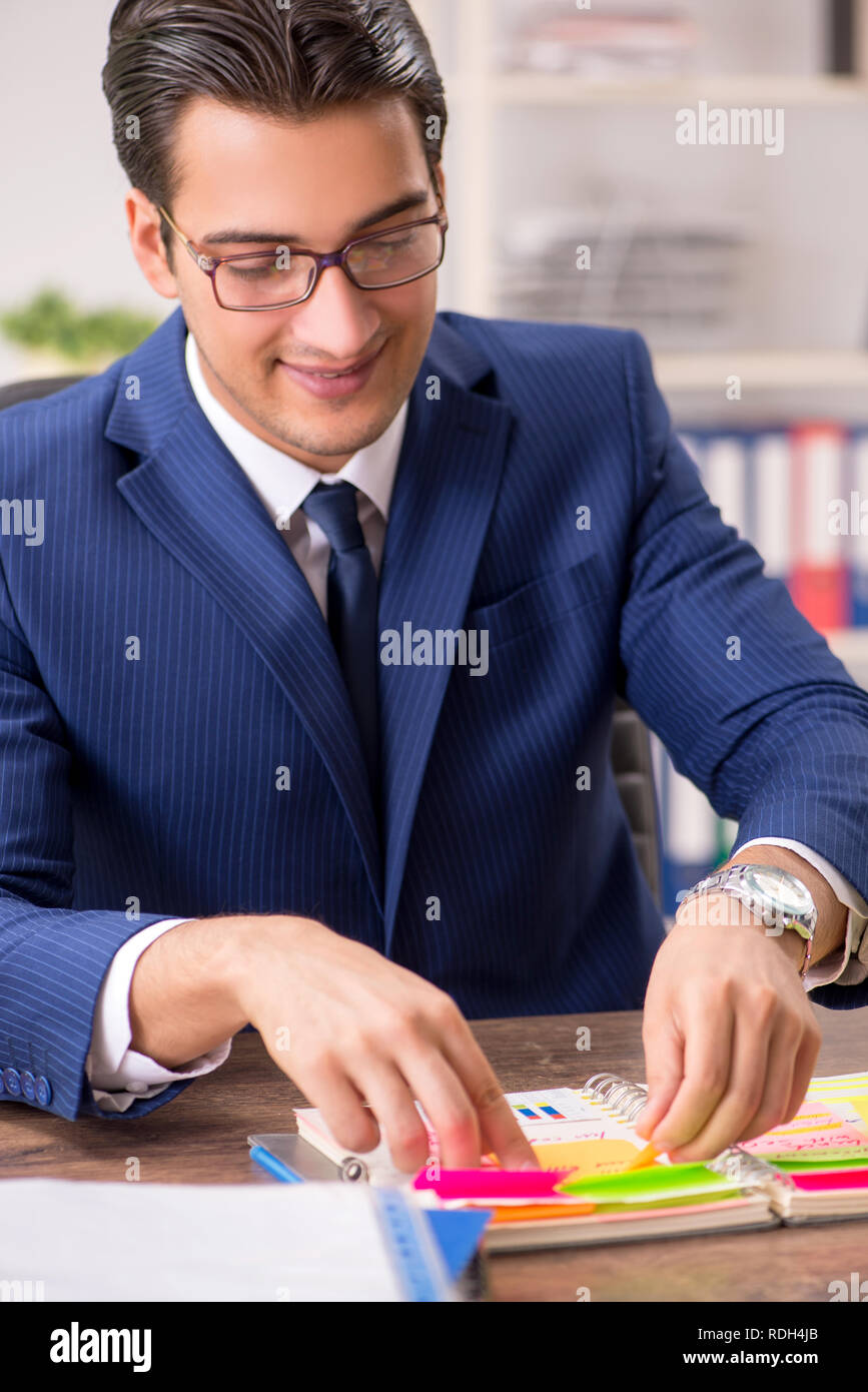 Young handsome employee planning his work activity Stock Photo - Alamy