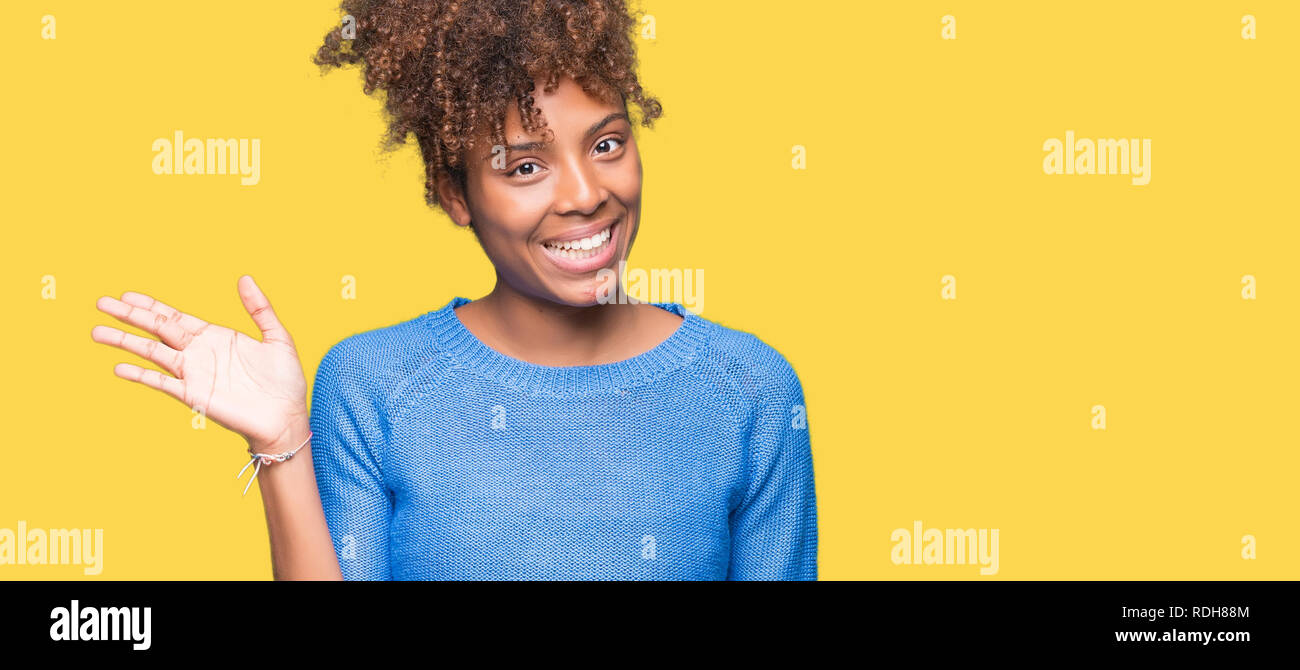 Beautiful young african american woman over isolated background Waiving ...