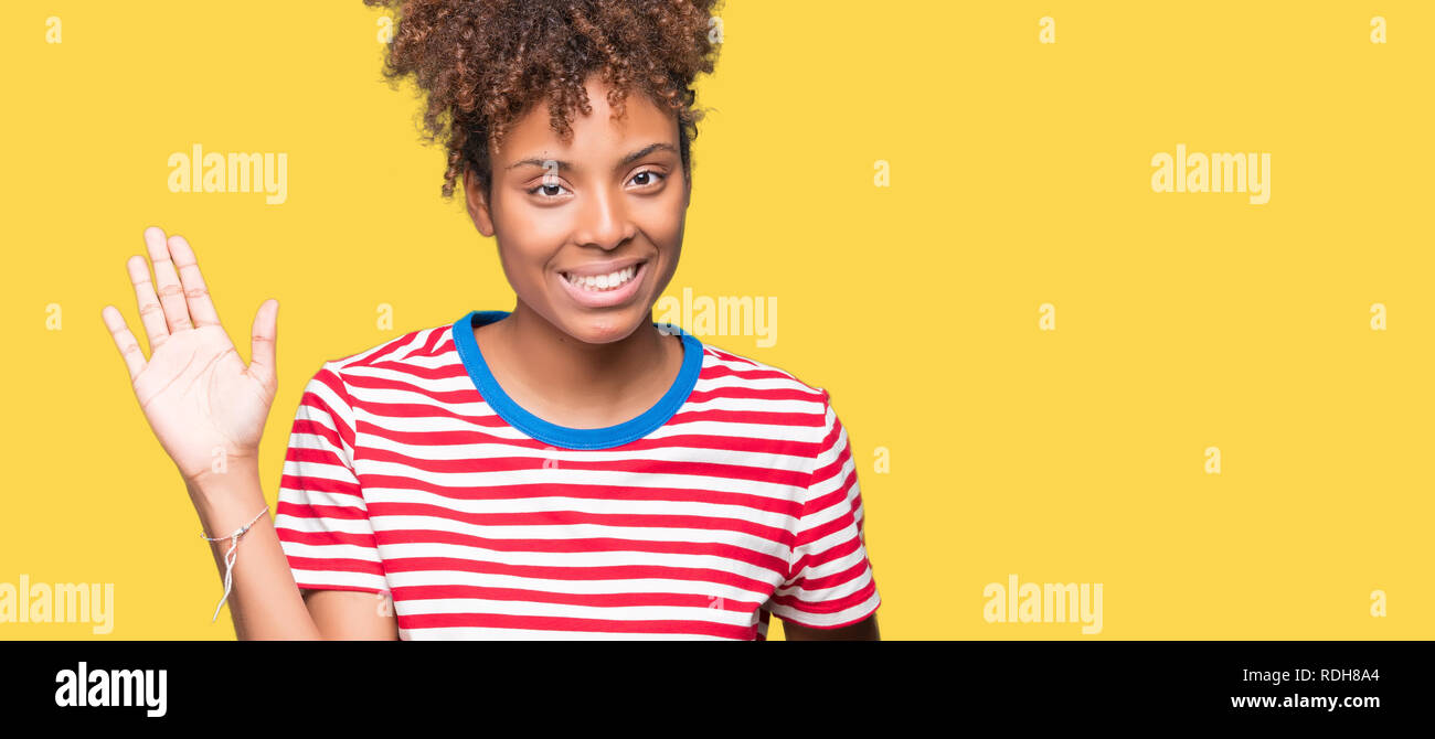 Beautiful young african american woman over isolated background Waiving ...