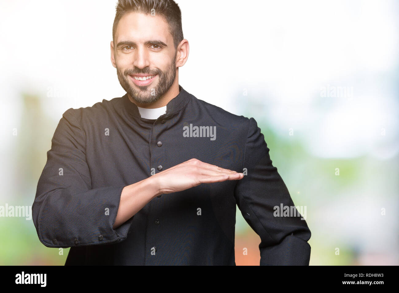 Young Christian priest over isolated background gesturing with hands ...