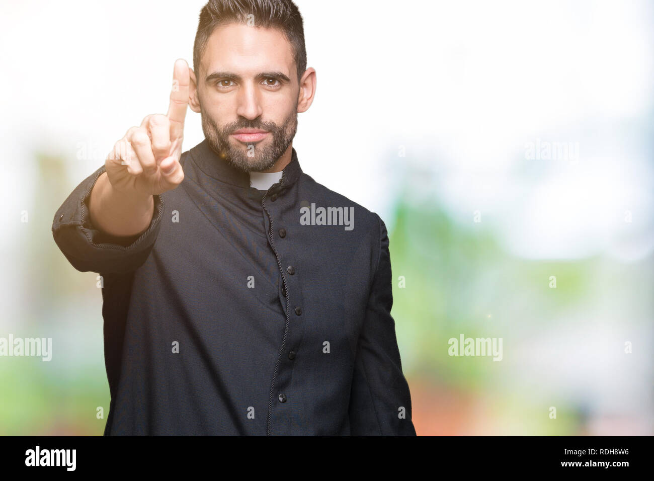 Young Christian priest over isolated background Pointing with finger up ...