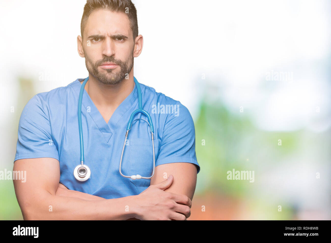 Handsome young doctor surgeon man over isolated background skeptic and ...