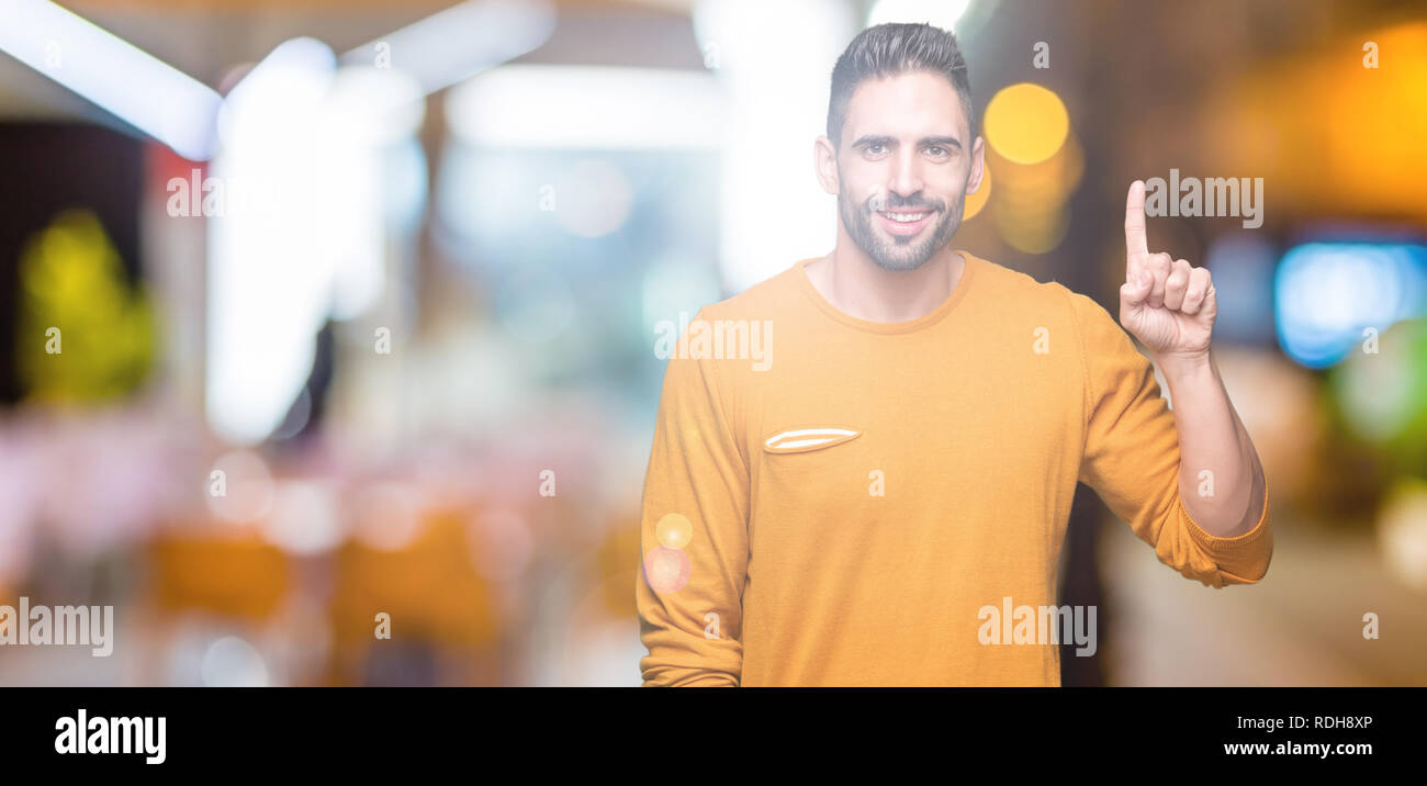Young handsome man over isolated background showing and pointing up ...