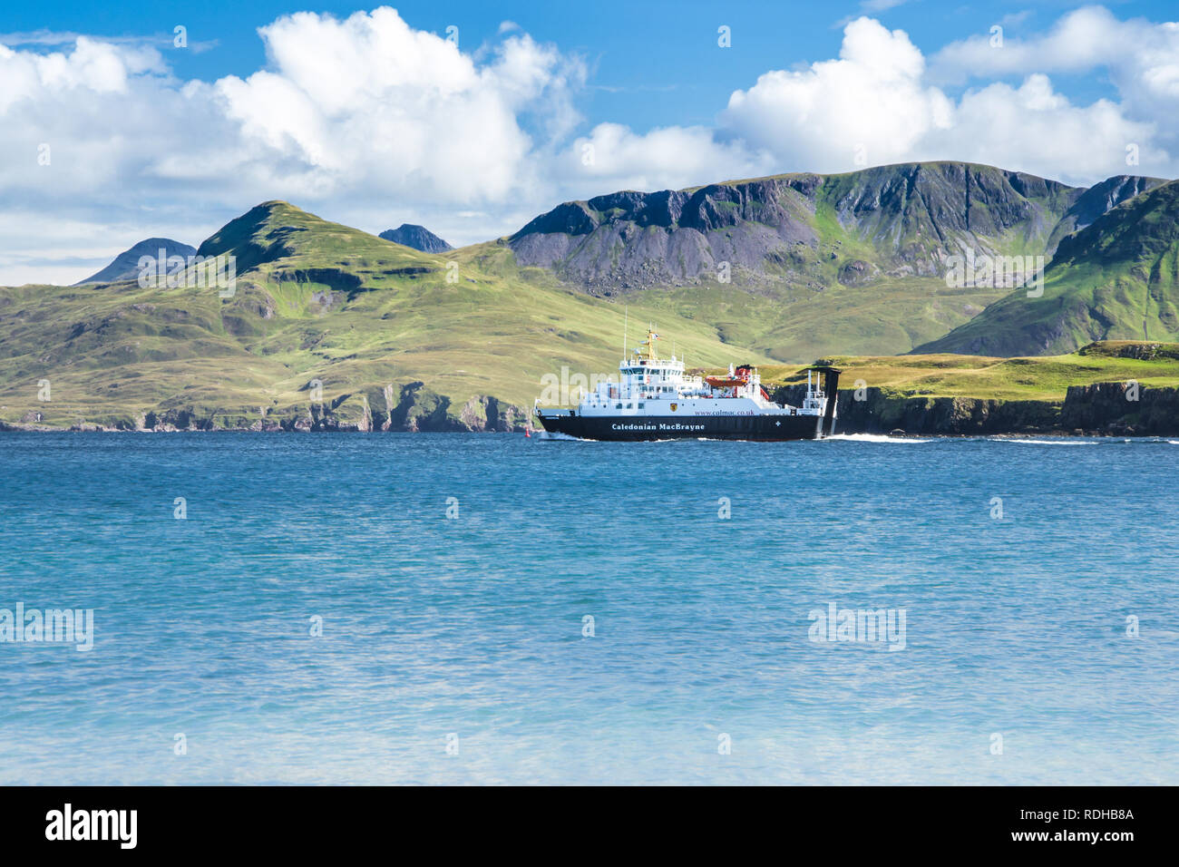 Calmac ferry on the sea with green mountains in the background ...
