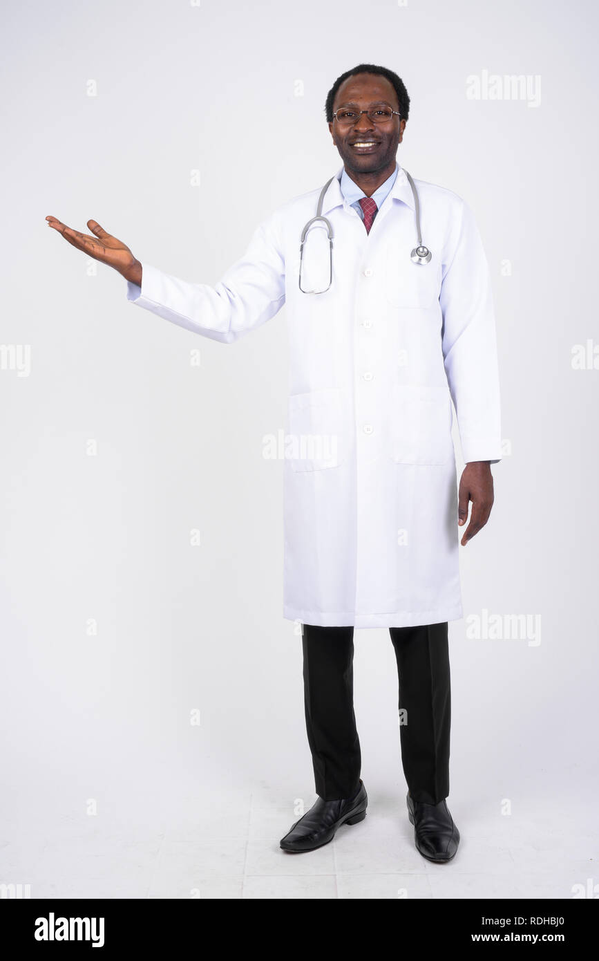 Full body shot of happy African man doctor showing something Stock ...