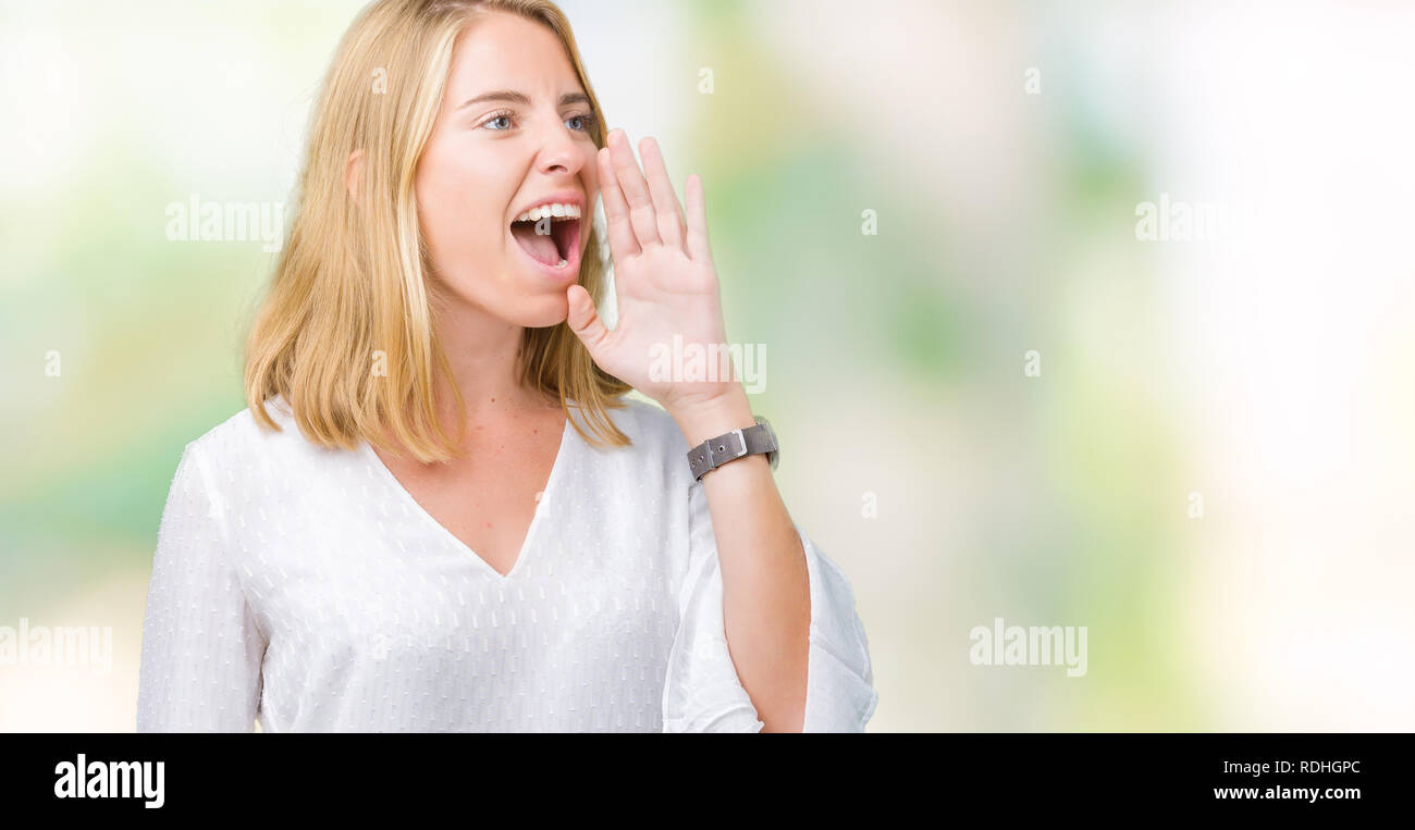 Beautiful young elegant woman over isolated background shouting and ...