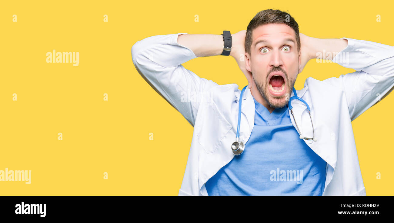 Handsome doctor man wearing medical uniform over isolated background ...