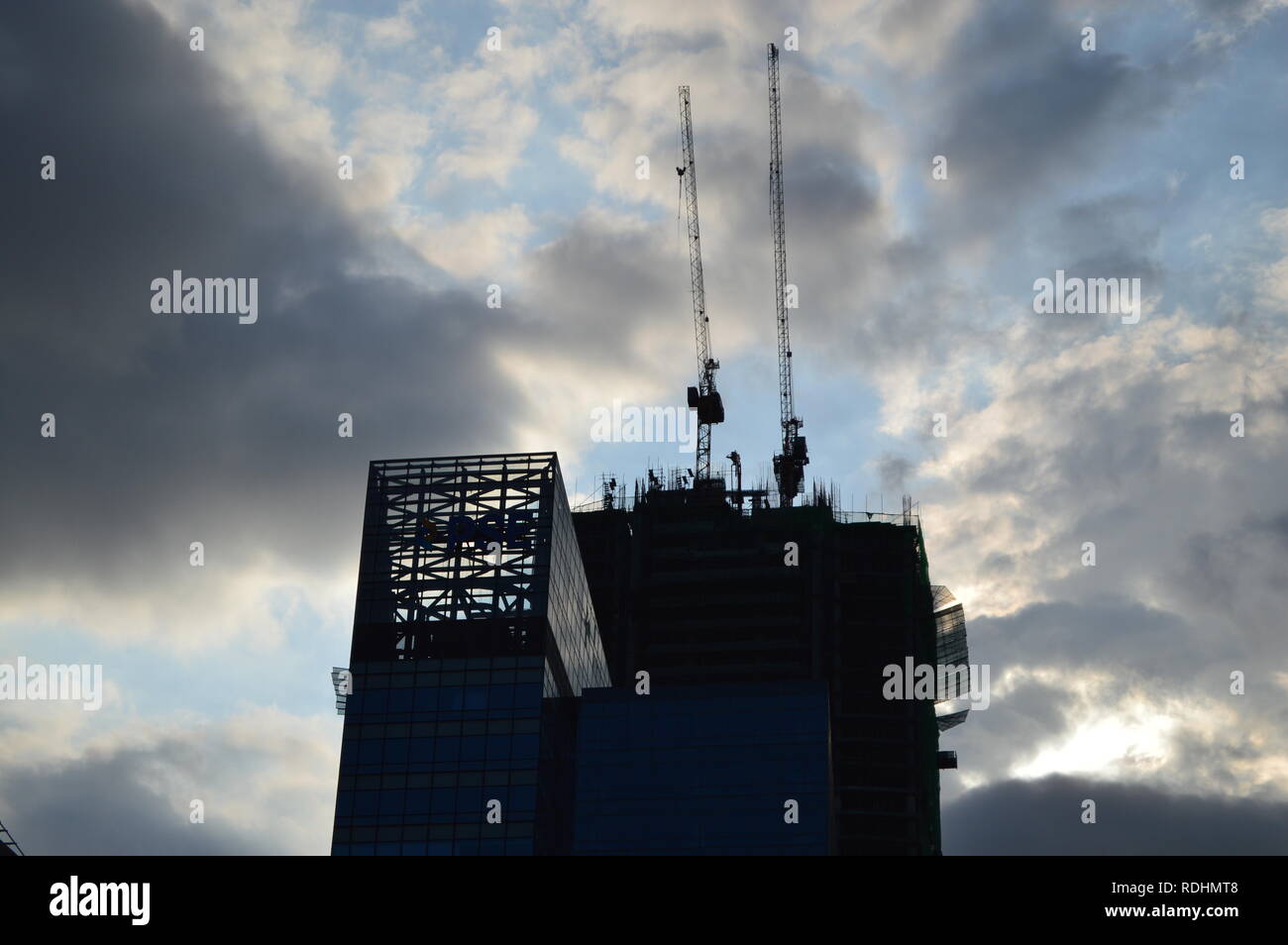 A building being constructed in a cloudy afternoon city Stock Photo - Alamy