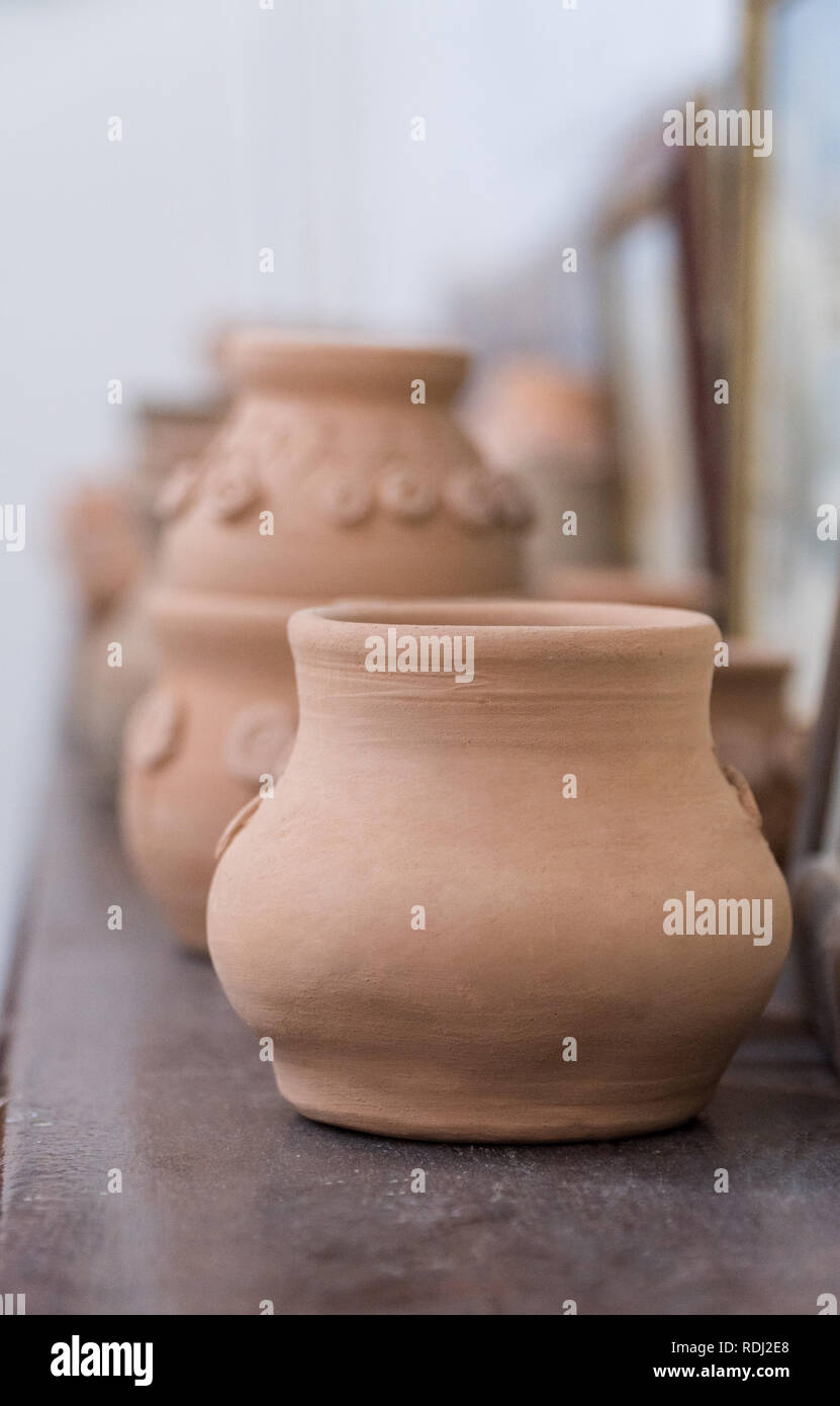 row of clay pots on the shelf, blurred background. children's crafts ...
