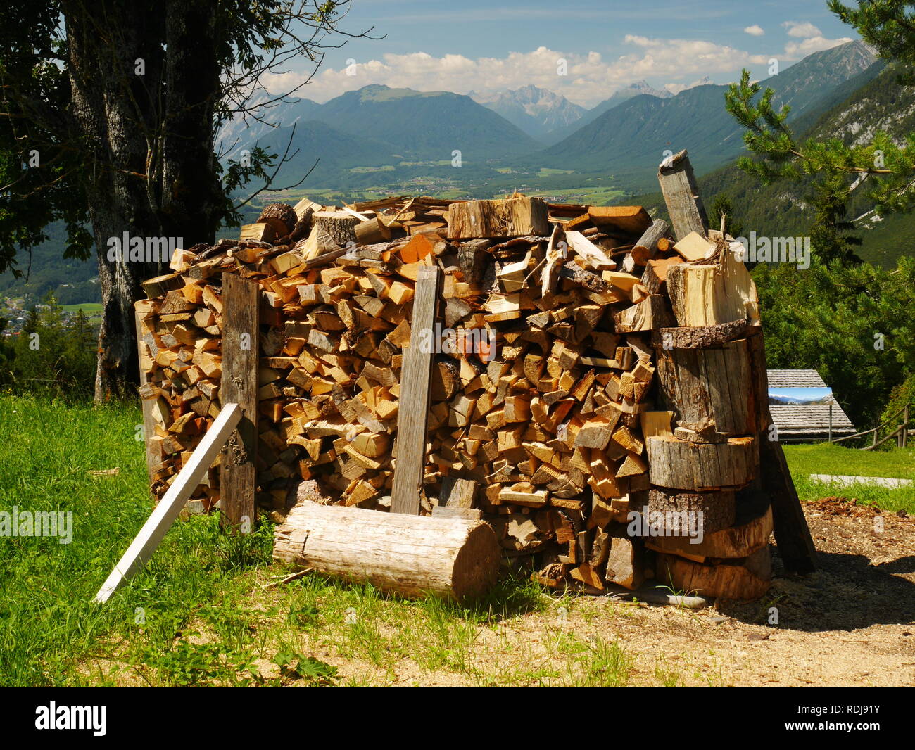 Stacked wood pile with valley and mountains behind, Tyrol, Austria ...