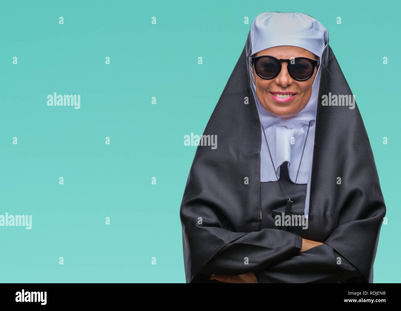 Middle age senior catholic nun woman wearing sunglasses over isolated ...