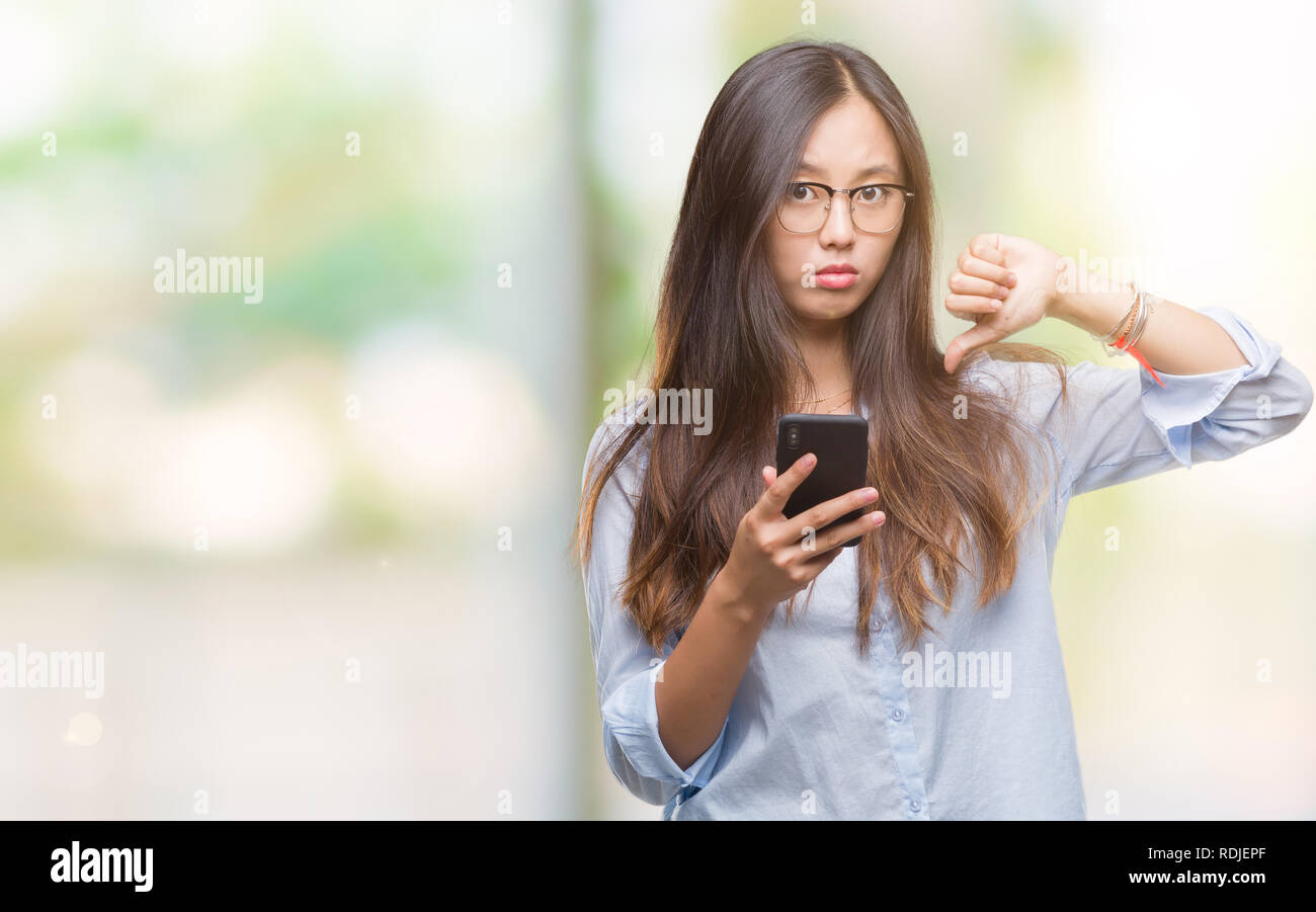Young asian woman texting using smartphone over isolated background ...