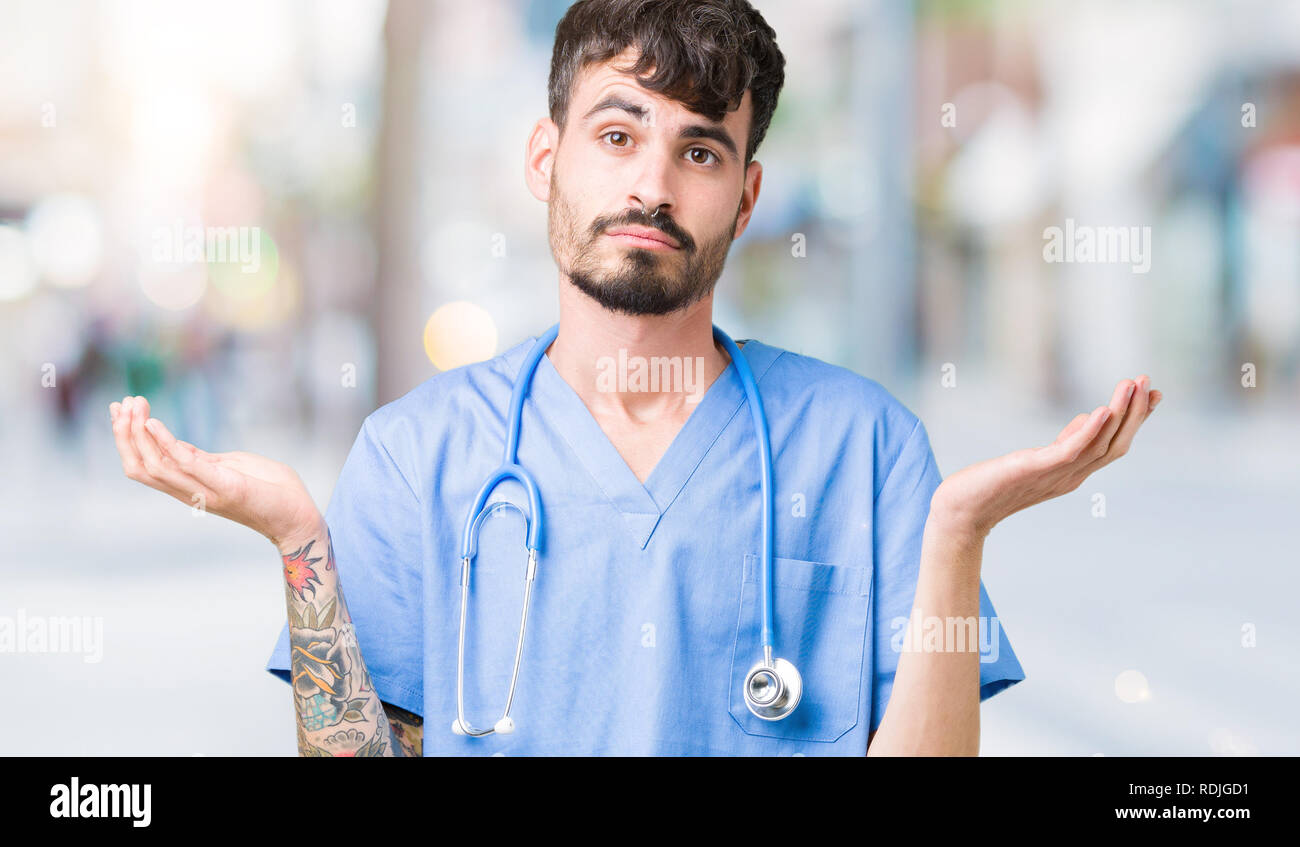 Young handsome nurse man wearing surgeon uniform over isolated ...
