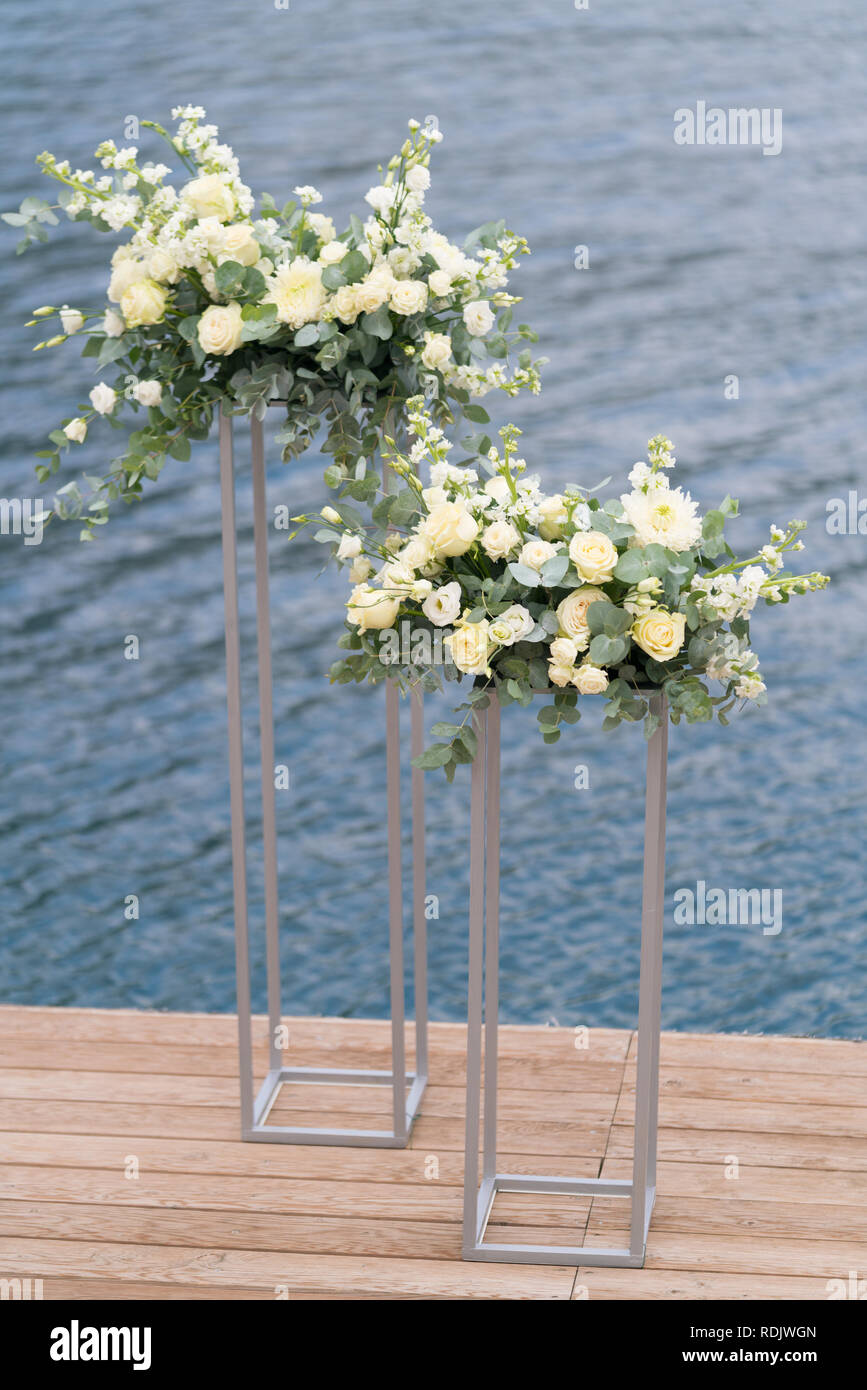modern stands with flowers on the background of the sea for the wedding ...