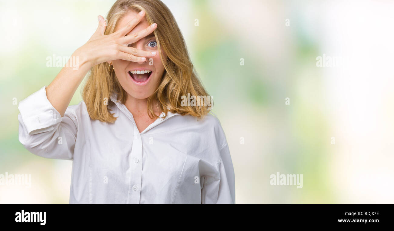 Beautiful young business woman over isolated background peeking in ...