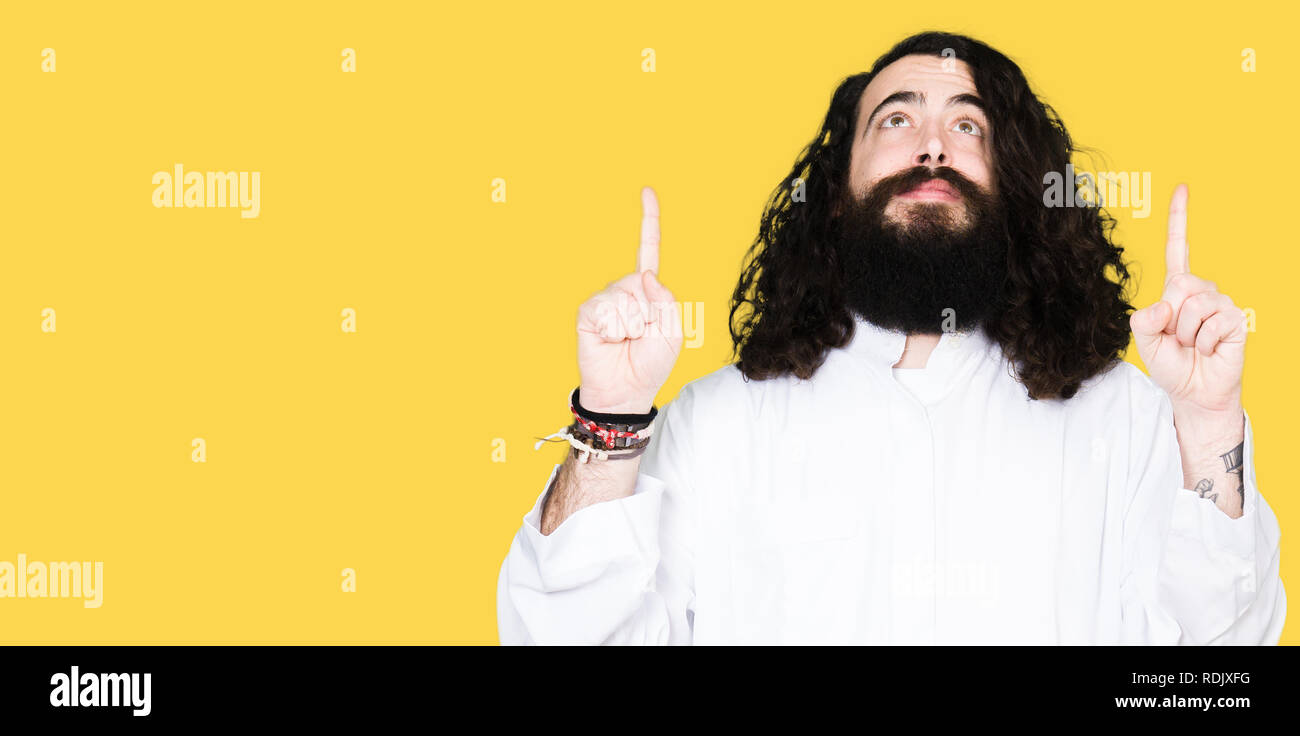 Man wearing Jesus Christ costume amazed and surprised looking up and ...