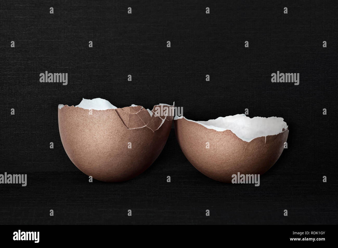 Broken egg shell, beige on black cloth background Stock Photo - Alamy