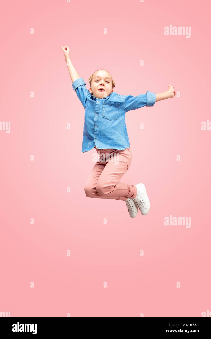 Young happy caucasian teen girl jumping in the air, isolated on pink ...