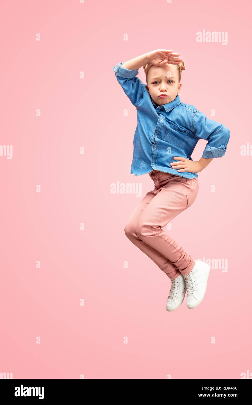 Young happy caucasian teen girl jumping in the air, isolated on pink ...