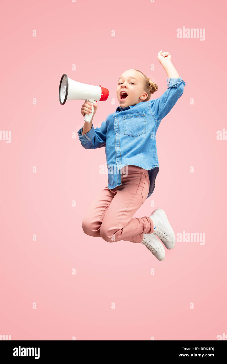 Beautiful young child teen girl jumping with megaphone isolated over ...