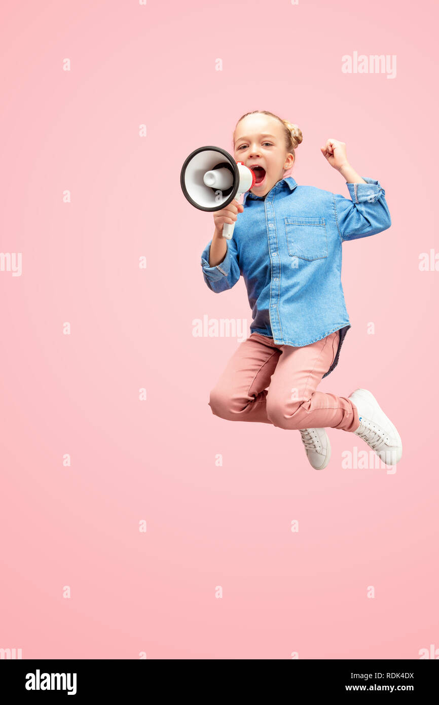 Beautiful young child teen girl jumping with megaphone isolated over ...