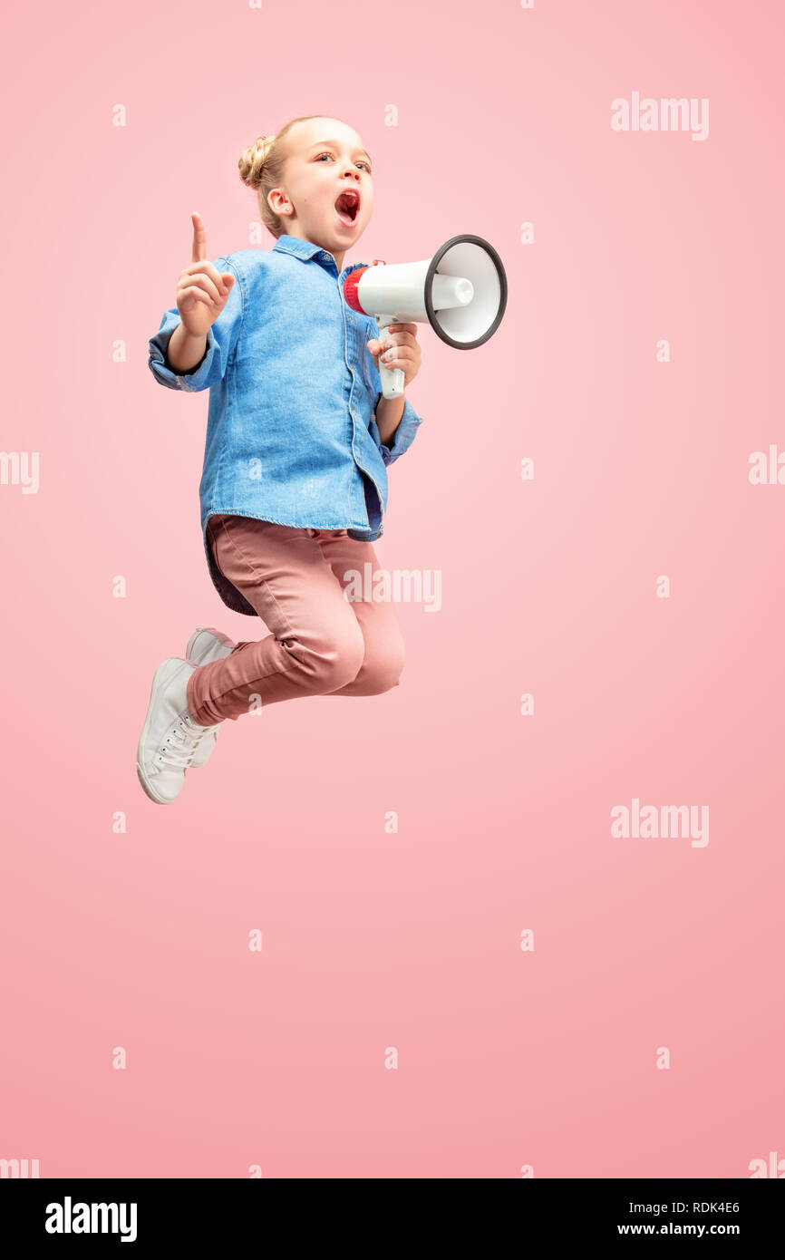 Beautiful young child teen girl jumping with megaphone isolated over ...