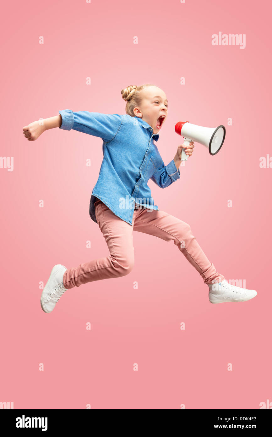 Beautiful young child teen girl jumping with megaphone isolated over ...