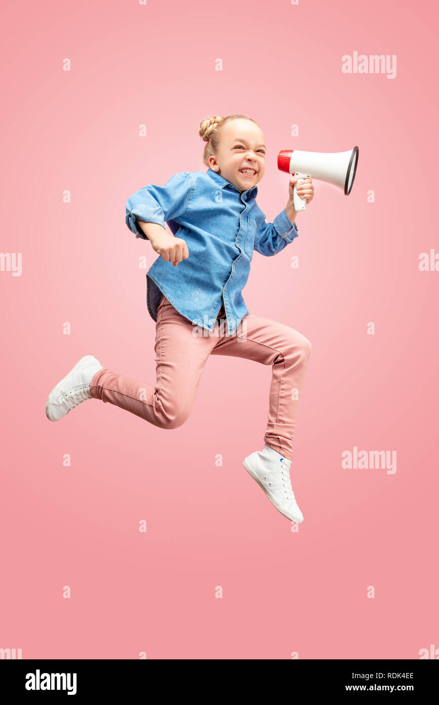 Beautiful young child teen girl jumping with megaphone isolated over ...
