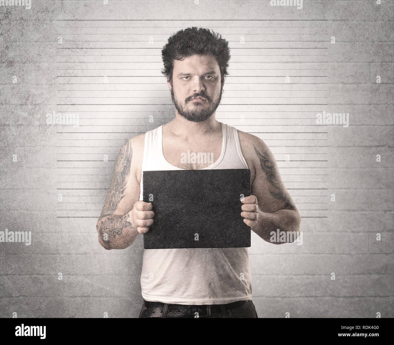 Gangster in front of a wall with table on his hand Stock Photo - Alamy