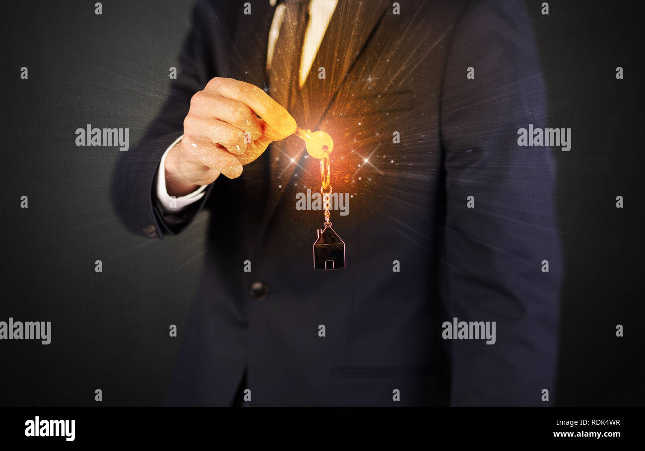 Formal man hand over shiny keys with dark background Stock Photo - Alamy