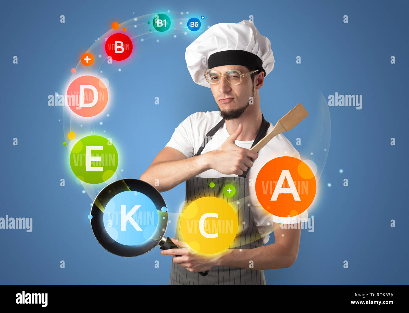 Handsome cook with kitchen instruments and vitamin concept Stock Photo ...