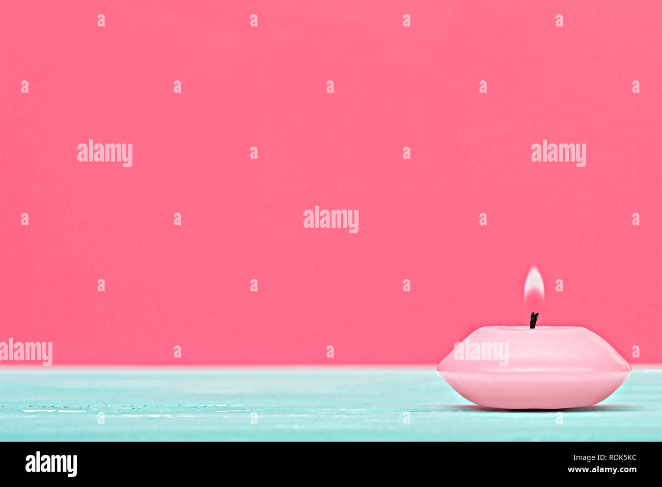 One little candle, isolated on pastel pink background (selective focus ...
