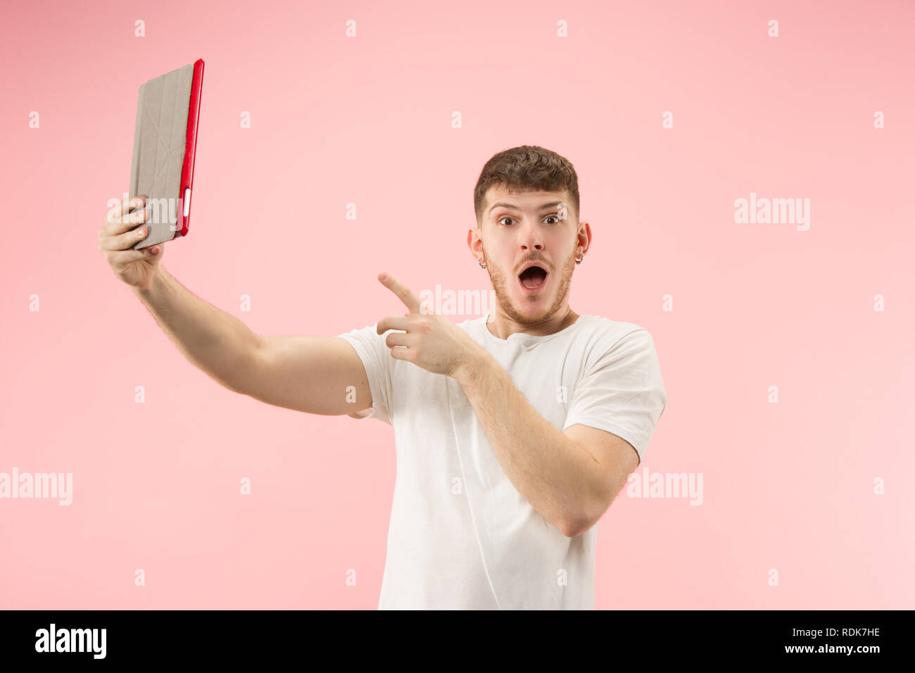 portrait of smiling man pointing at laptop with blank screen isolated ...