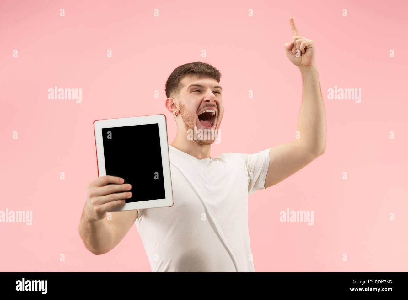 portrait of smiling man pointing at laptop with blank screen isolated ...