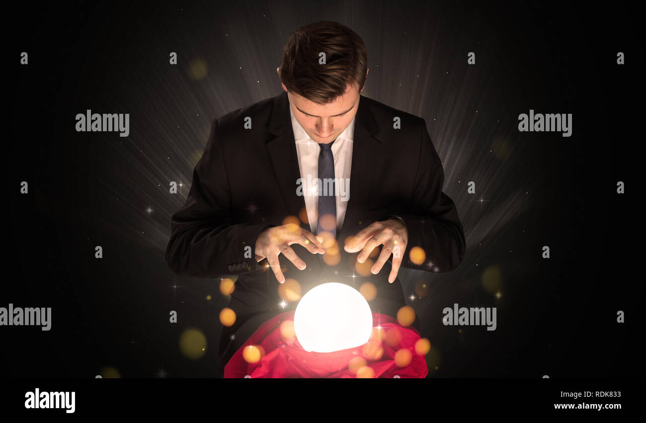 Gorgeous businessman sitting with sparkling magic ball in his lap Stock ...
