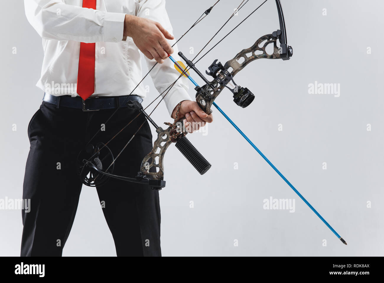 Businessman aiming at target with bow and arrow, isolated on gray ...
