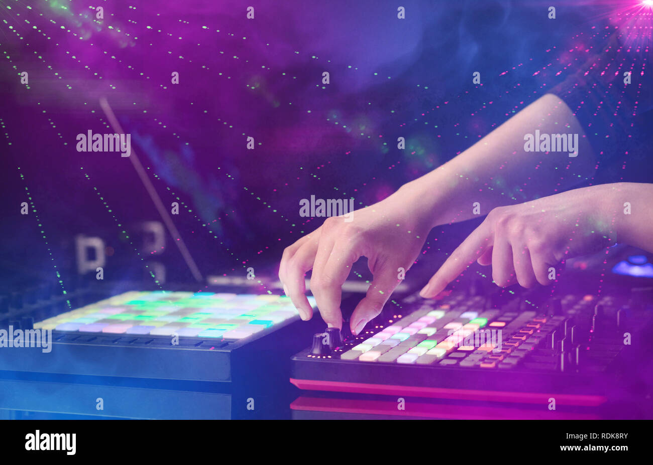 Hand mixing music on midi controller with party club colors around ...