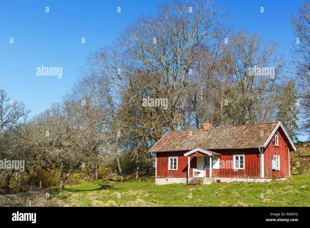 Red cottage in a beautiful spring landscape Stock Photo - Alamy