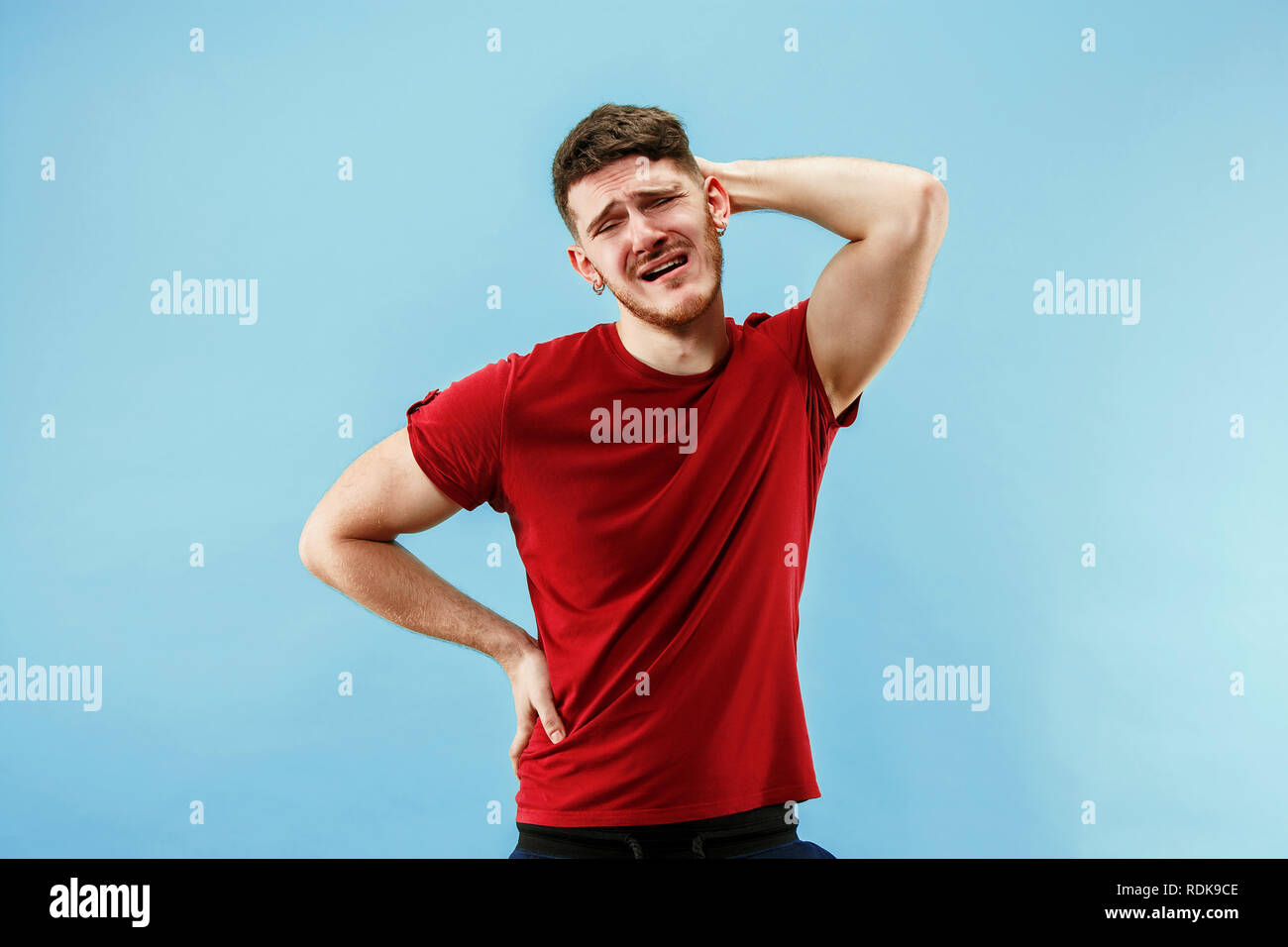 Man having headache. Isolated on blue background. Business man standing ...